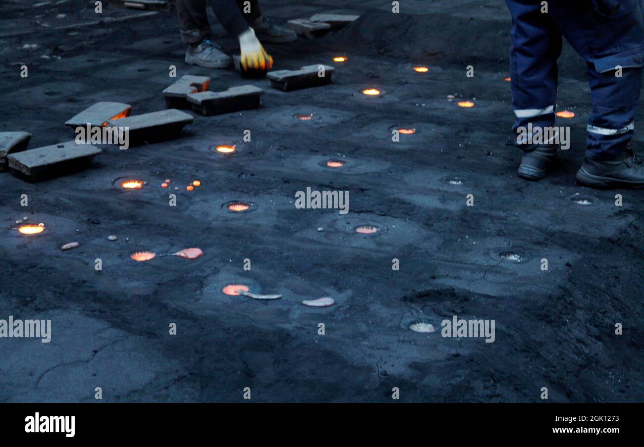Steel factory. Liquid metal in molds Stock Photo - Alamy