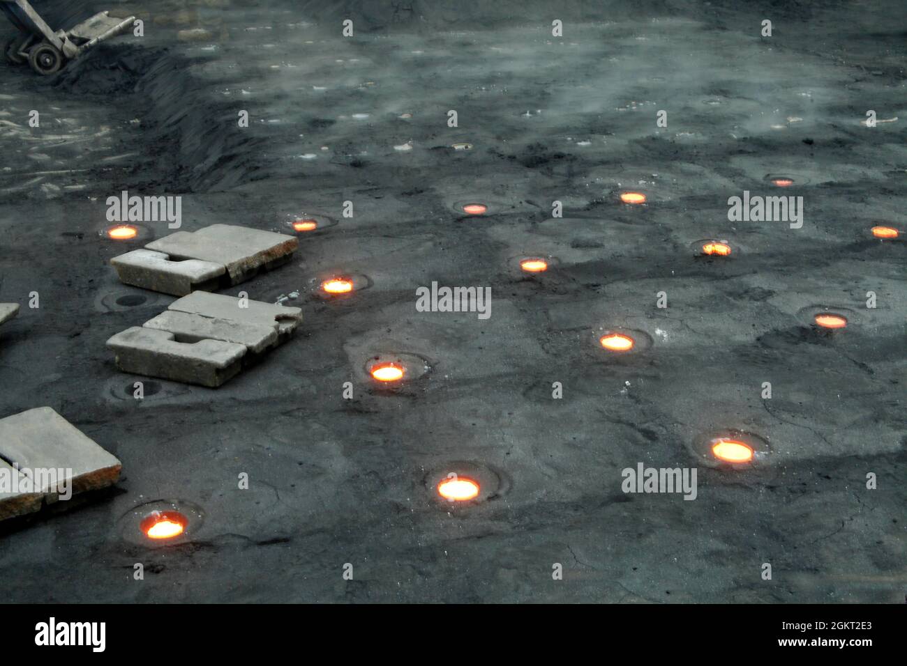 Steel factory. Liquid metal in molds Stock Photo - Alamy