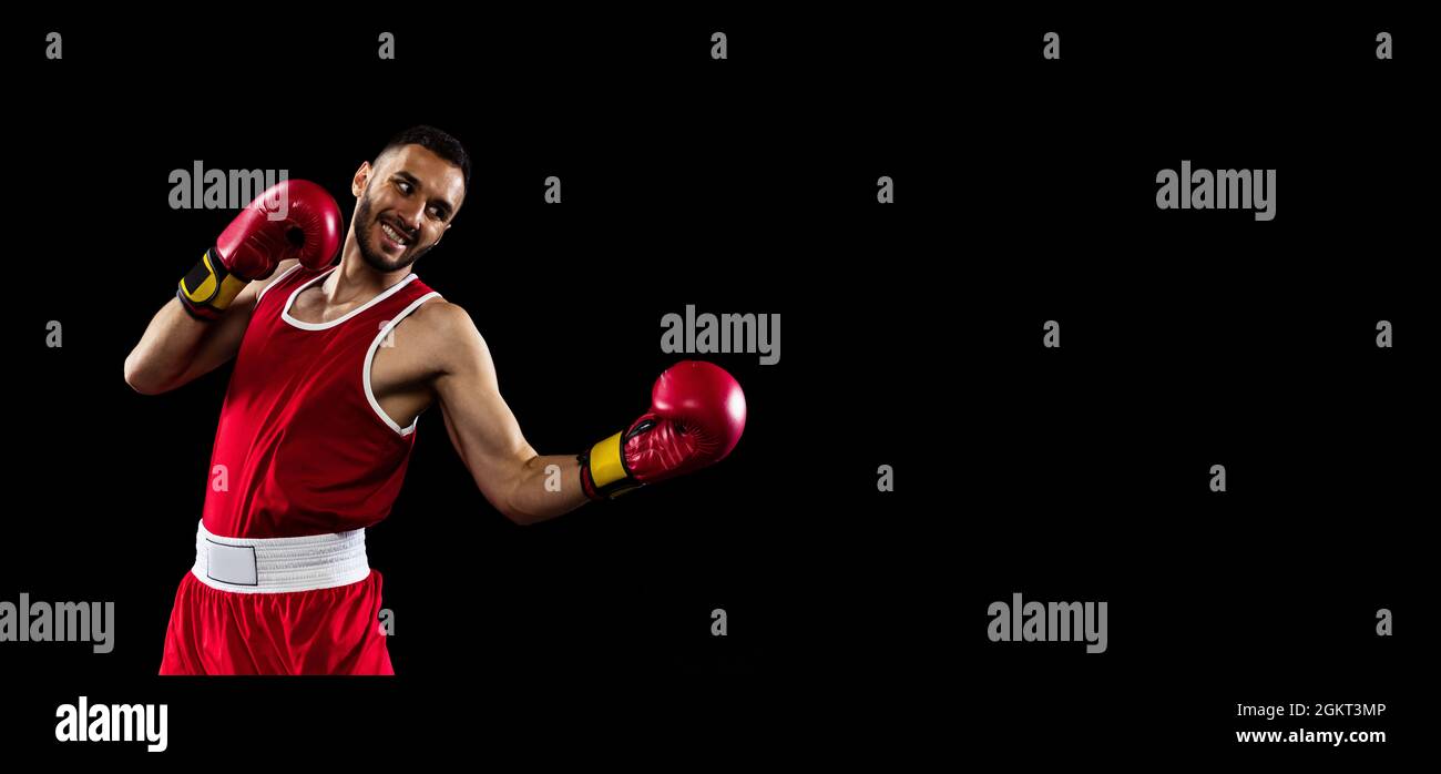 Cropped portrait of one professional boxer in red uniform training ...
