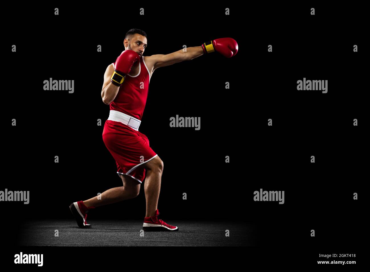 Full-length side view portrait of one professional boxer in red uniform ...