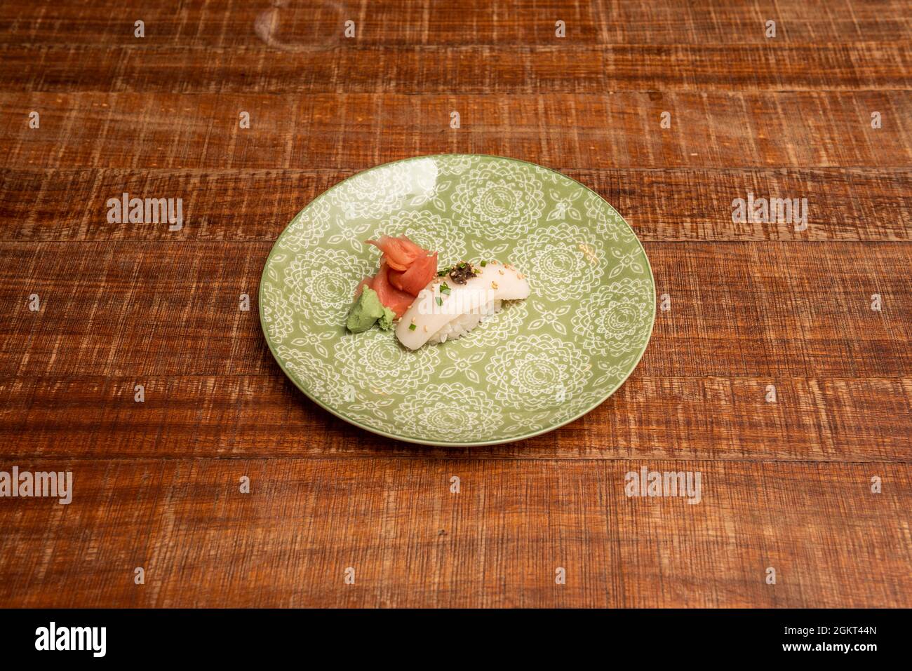 Delicious bite of butterfish sushi nigiri with wasabi and ginseng with ...
