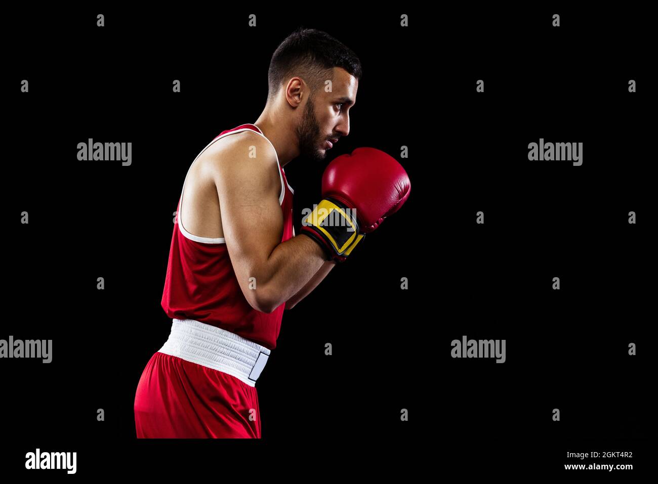 Side view portrait of young sportsman practicing boxing isolated over ...