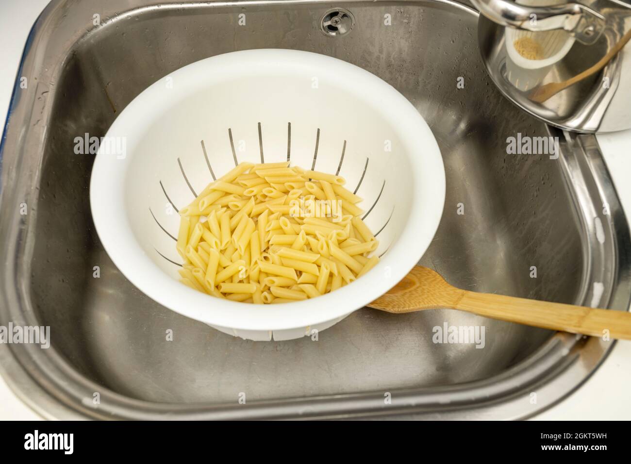 Draining macaroni to make an Italian pasta recipe with tomato and ...
