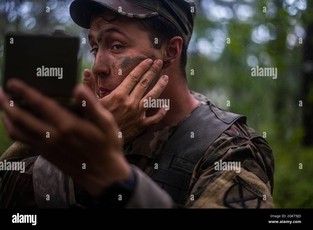 U.S. Army Soldier applies camouflage face paint during a situational ...