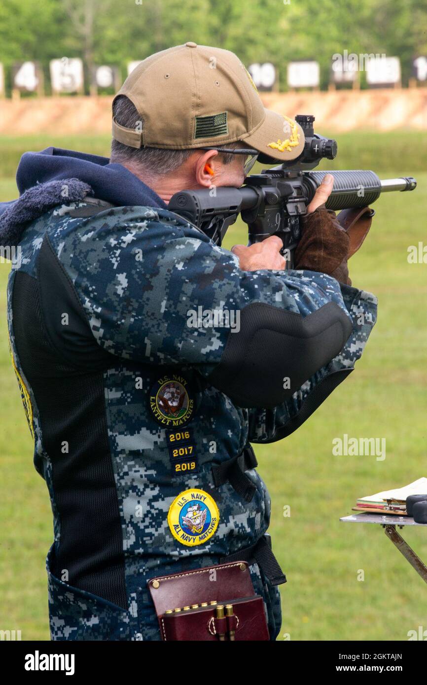 U.S. Navy Commander Roger Raber, with OPNAV N96, fires an M16 match ...