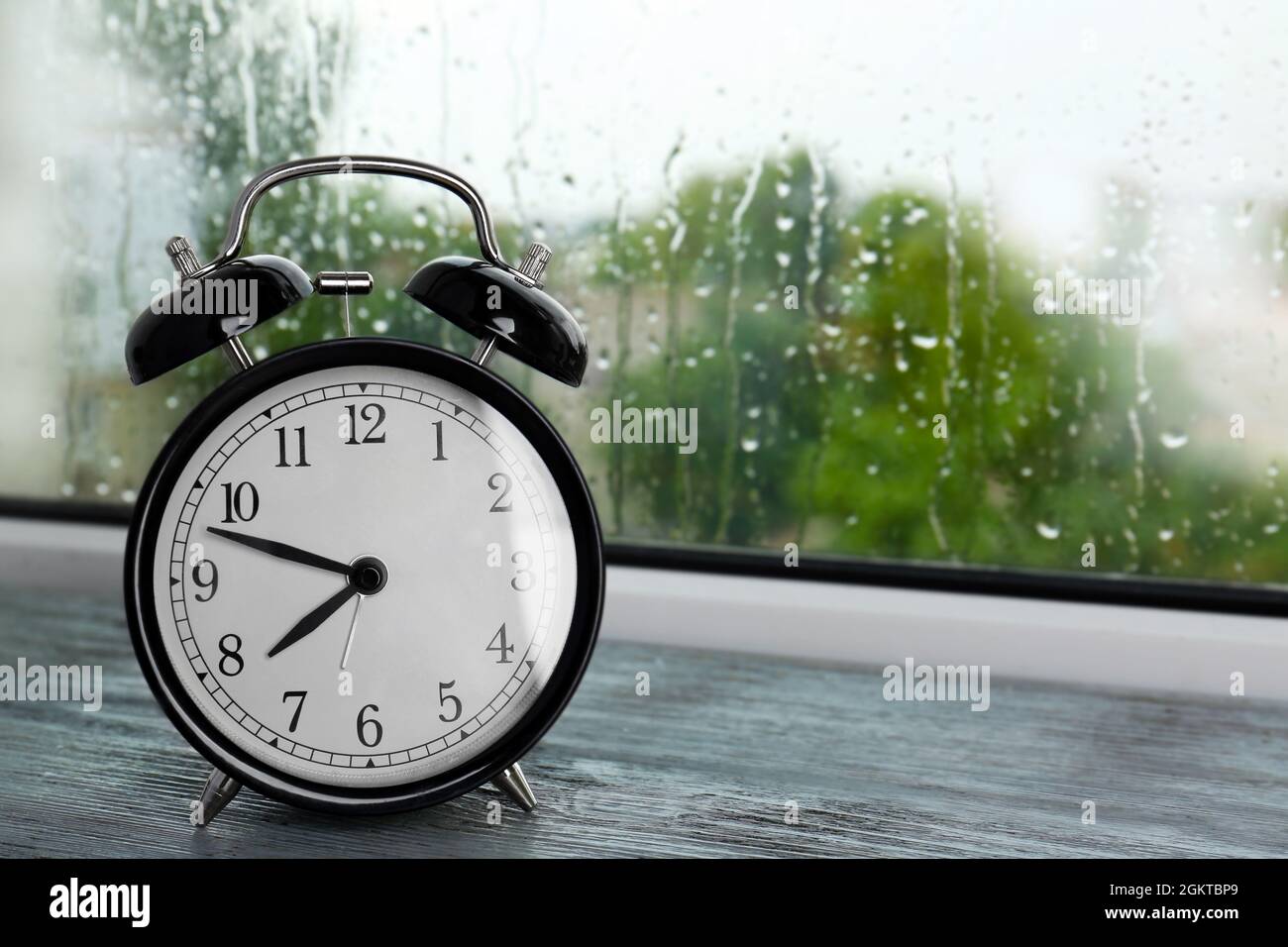 Alarm clock on wooden window sill. Morning routine concept Stock Photo ...
