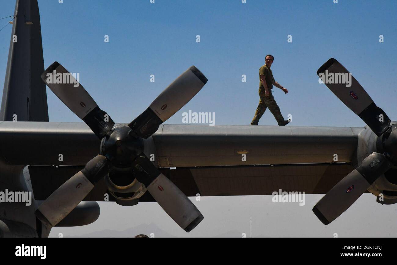 An Airman from the 55th Electronic Combat Group walks across the wing ...