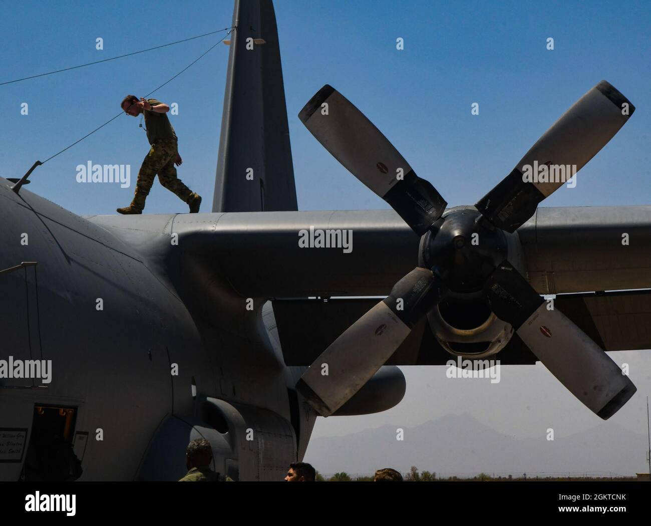 An Airman from the 55th Electronic Combat Group walks across the wing ...
