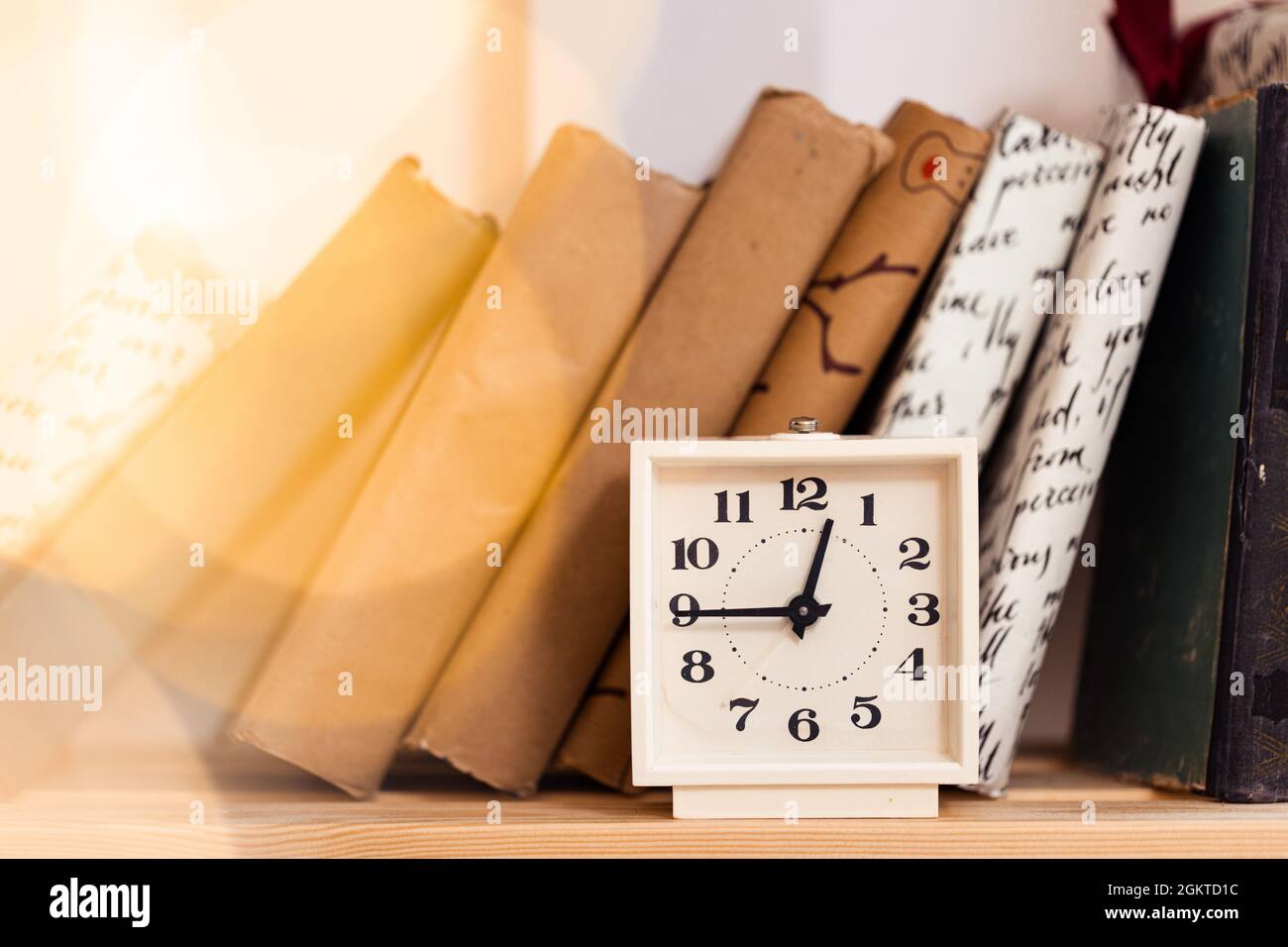 White vintage clock and pile of books Stock Photo - Alamy