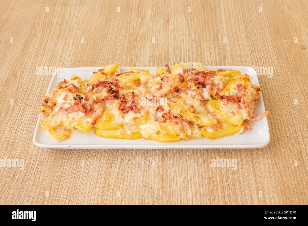 tray of delicious crisps with diced bacon and melted cheese on oak wood ...