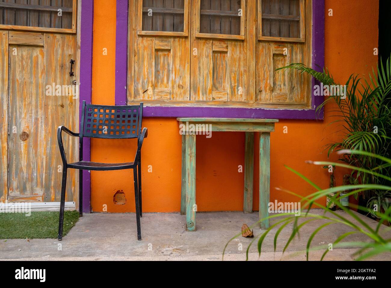 Closed doors with chair and table on patio of residential structure ...