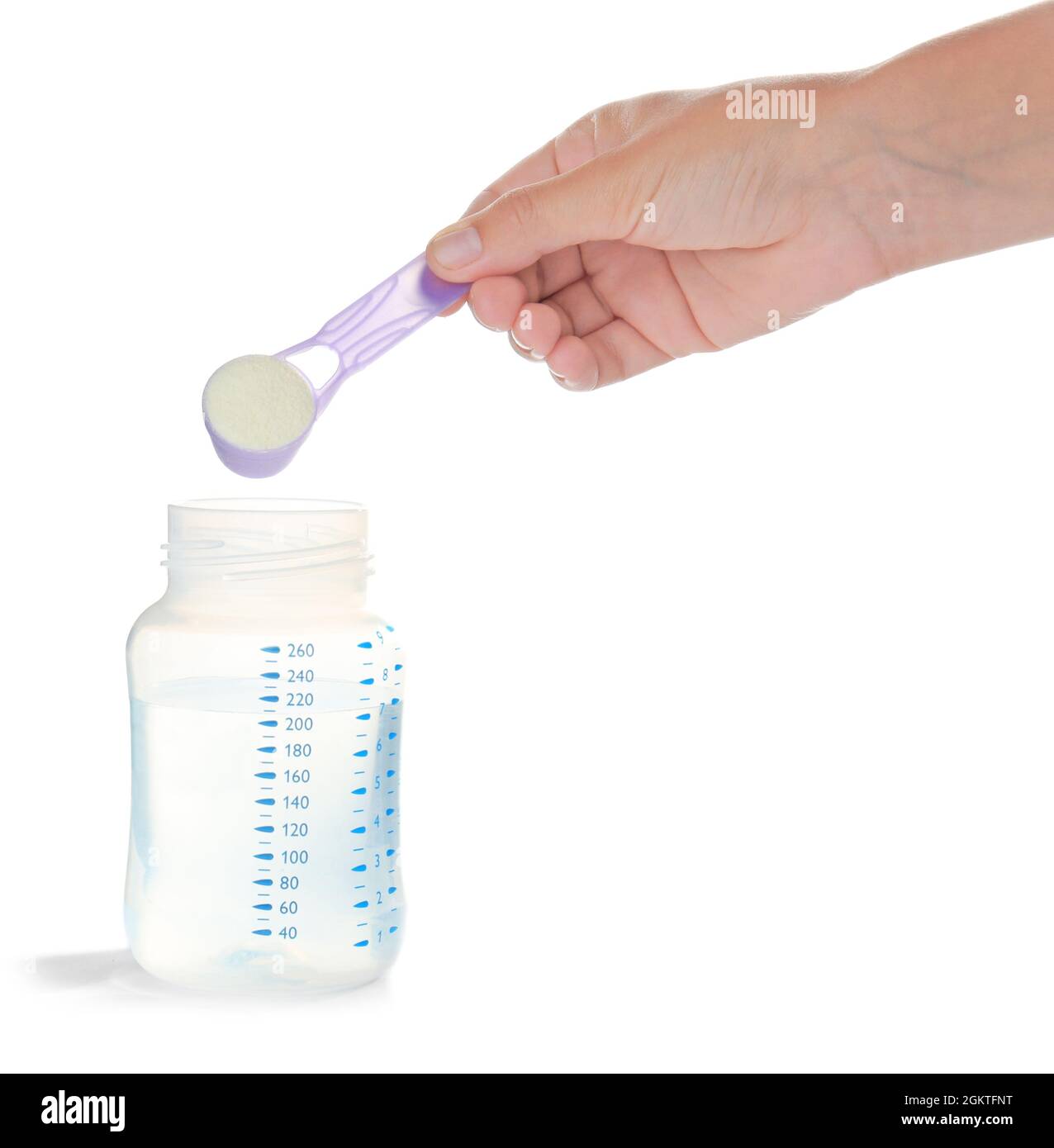 Woman's hand adding milk formula to water in baby bottle on white ...