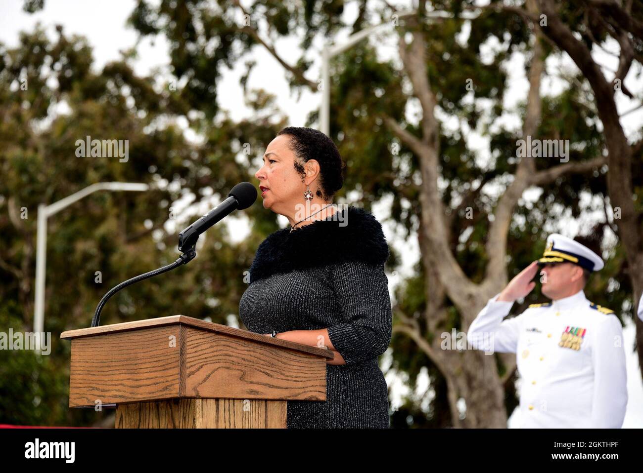 Desiree Jolly, a Coast Guard employee, sings the national anthem during ...