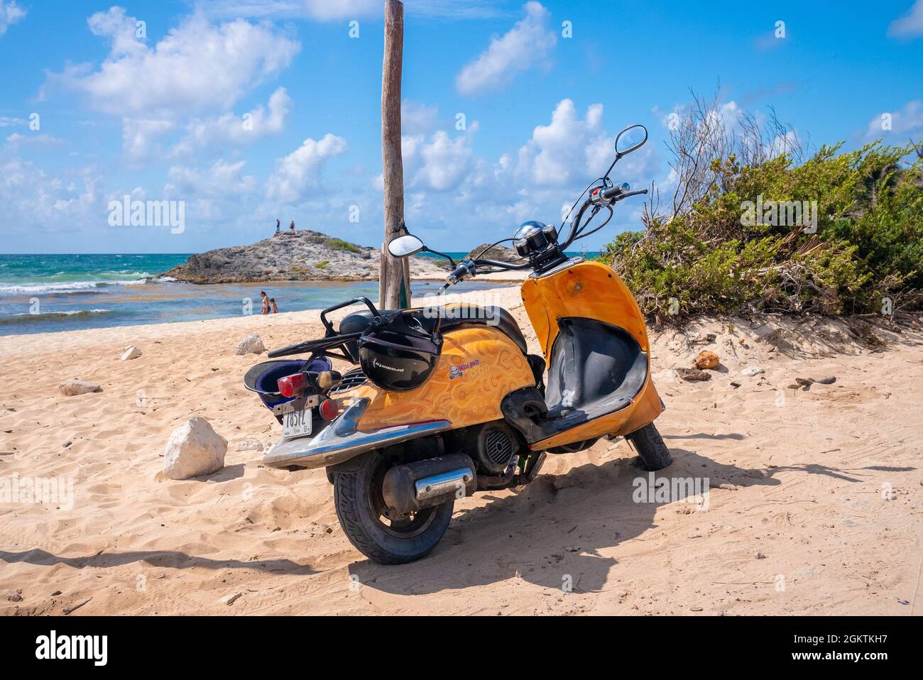 Yellow designed scooter parked on sand at beach on a sunny day Stock ...