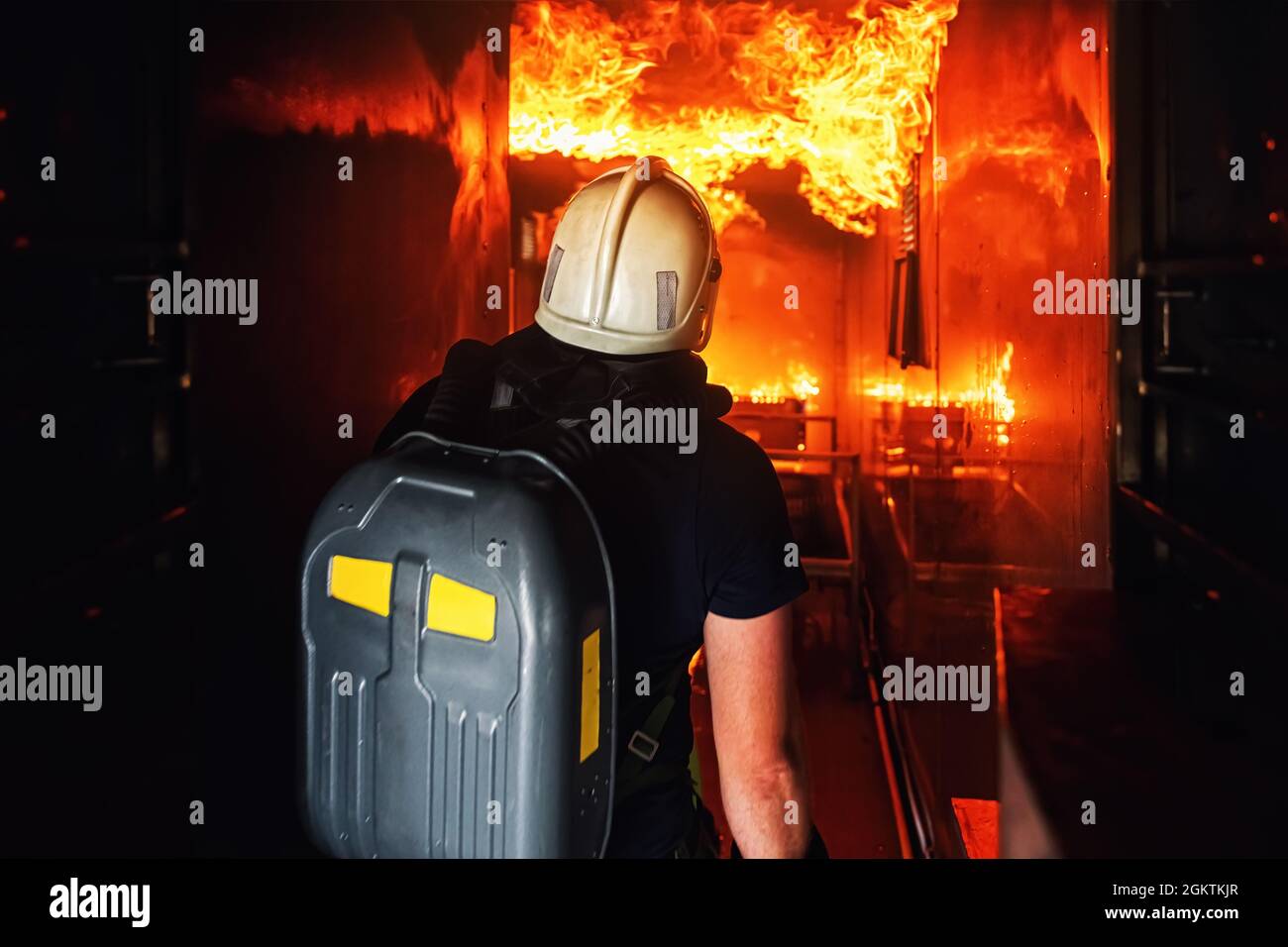 Volunteer firefighter enters burning room during an exercise to ...