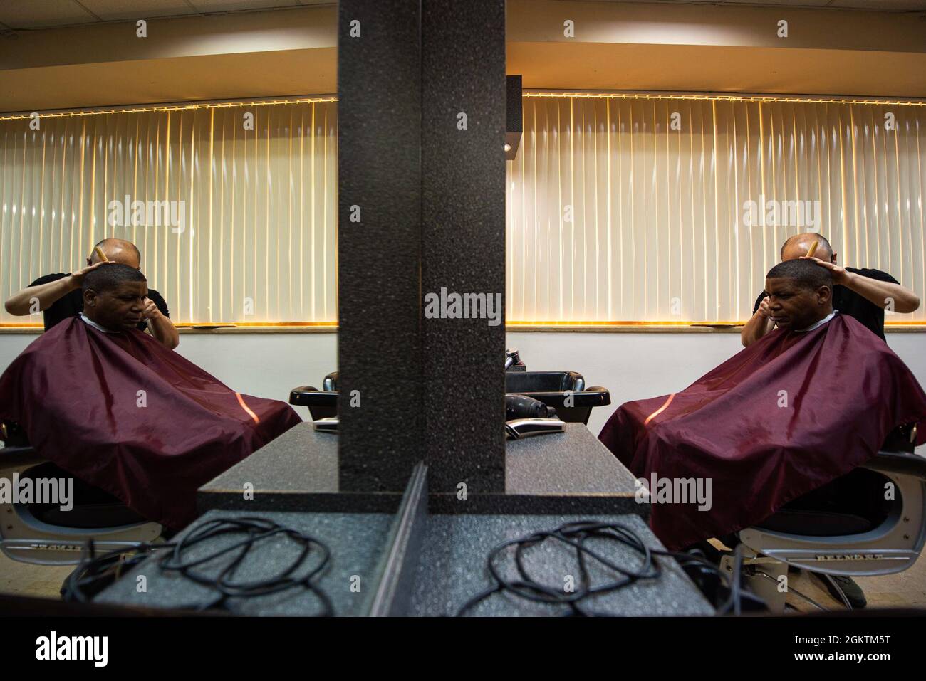 Maj. Gen. Randall Reed, Third Air Force commander, receives a haircut ...