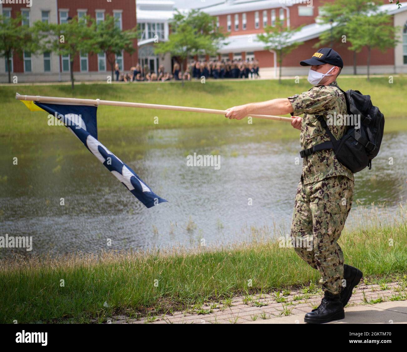 A recruit guideon presnets arms as he marches with his division in ...