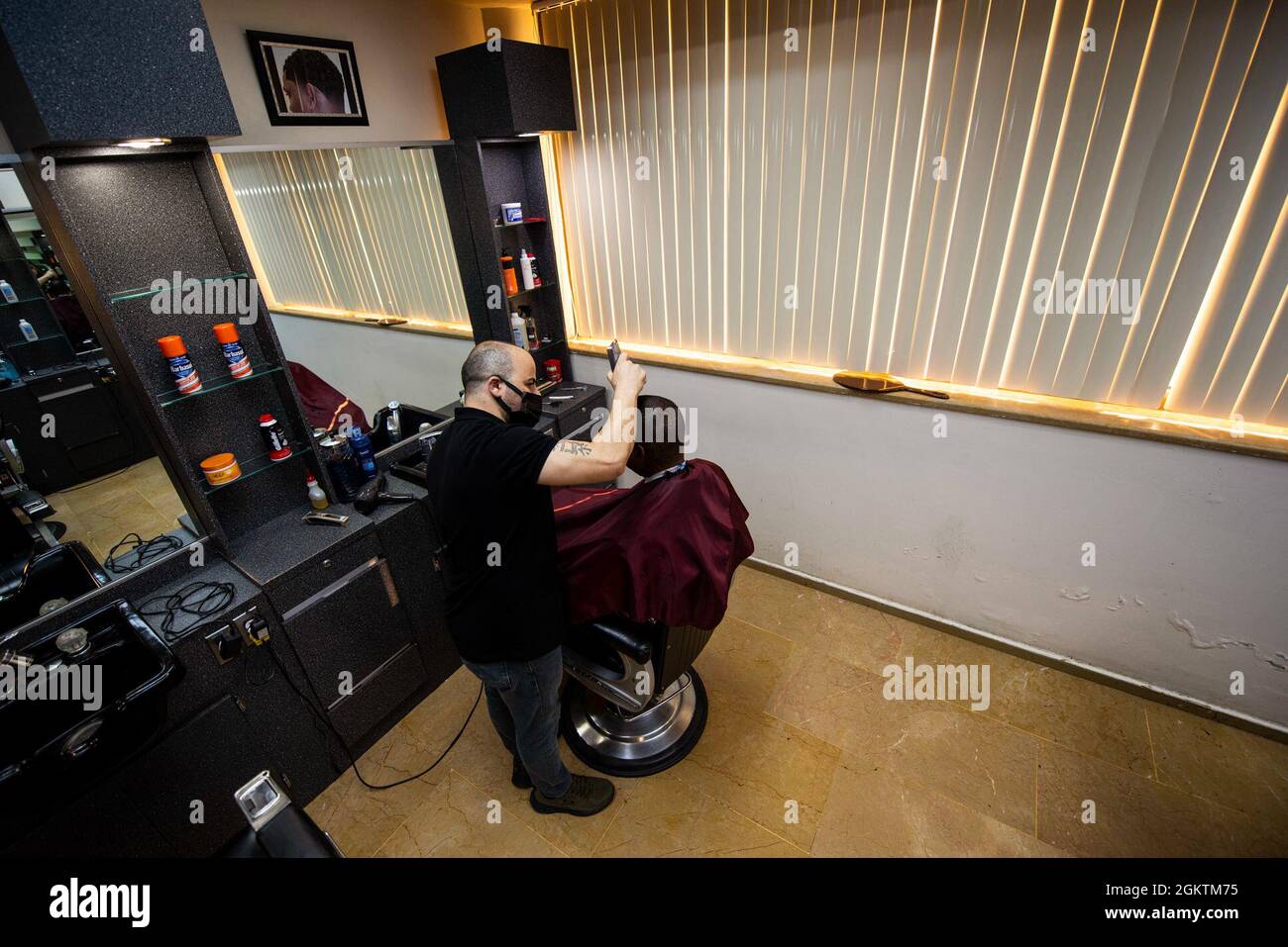 Maj. Gen. Randall Reed, Third Air Force commander, receives a haircut ...