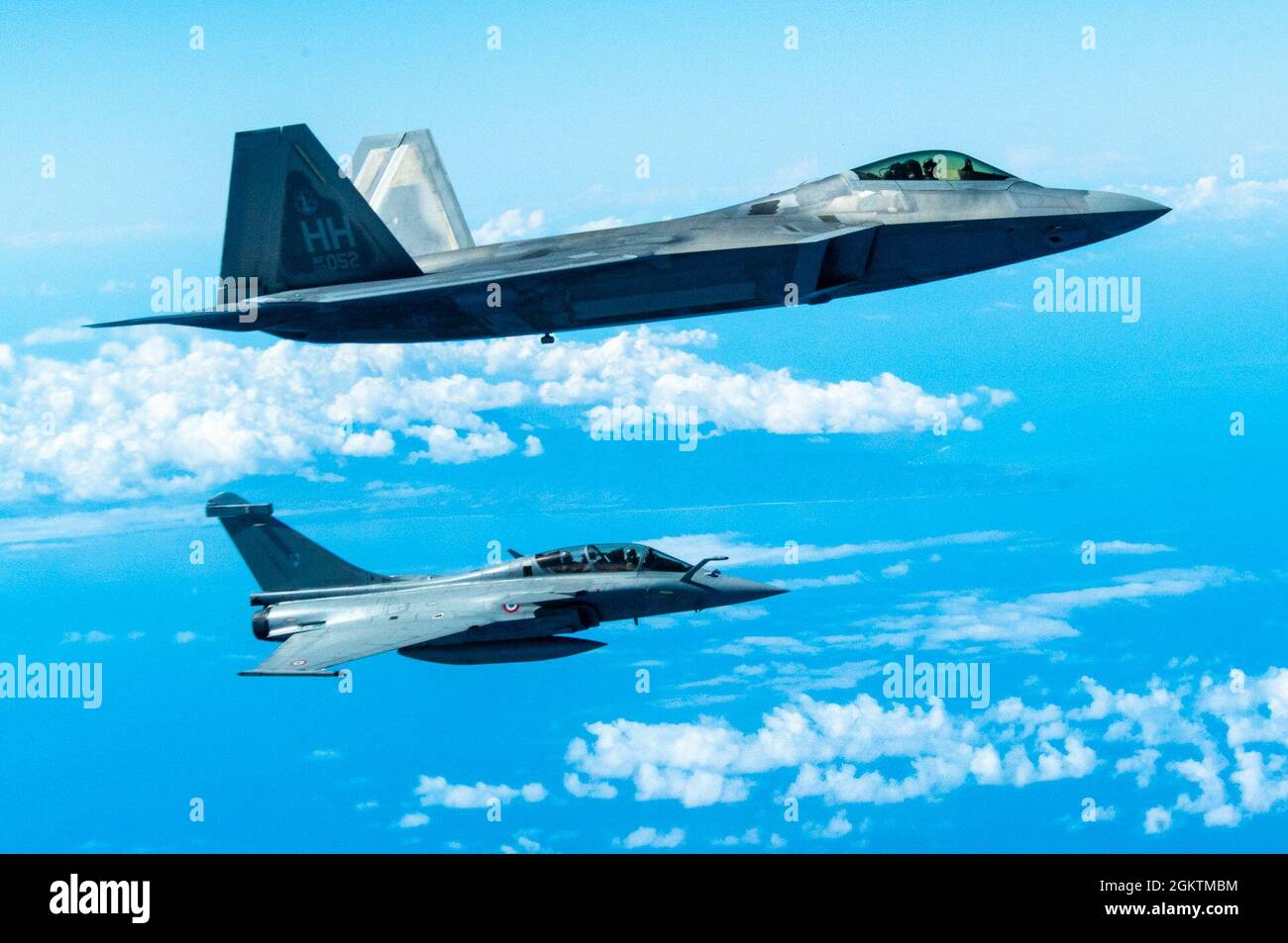 A Hawaii Air National Guard F-22 Raptor flies in formation with a ...
