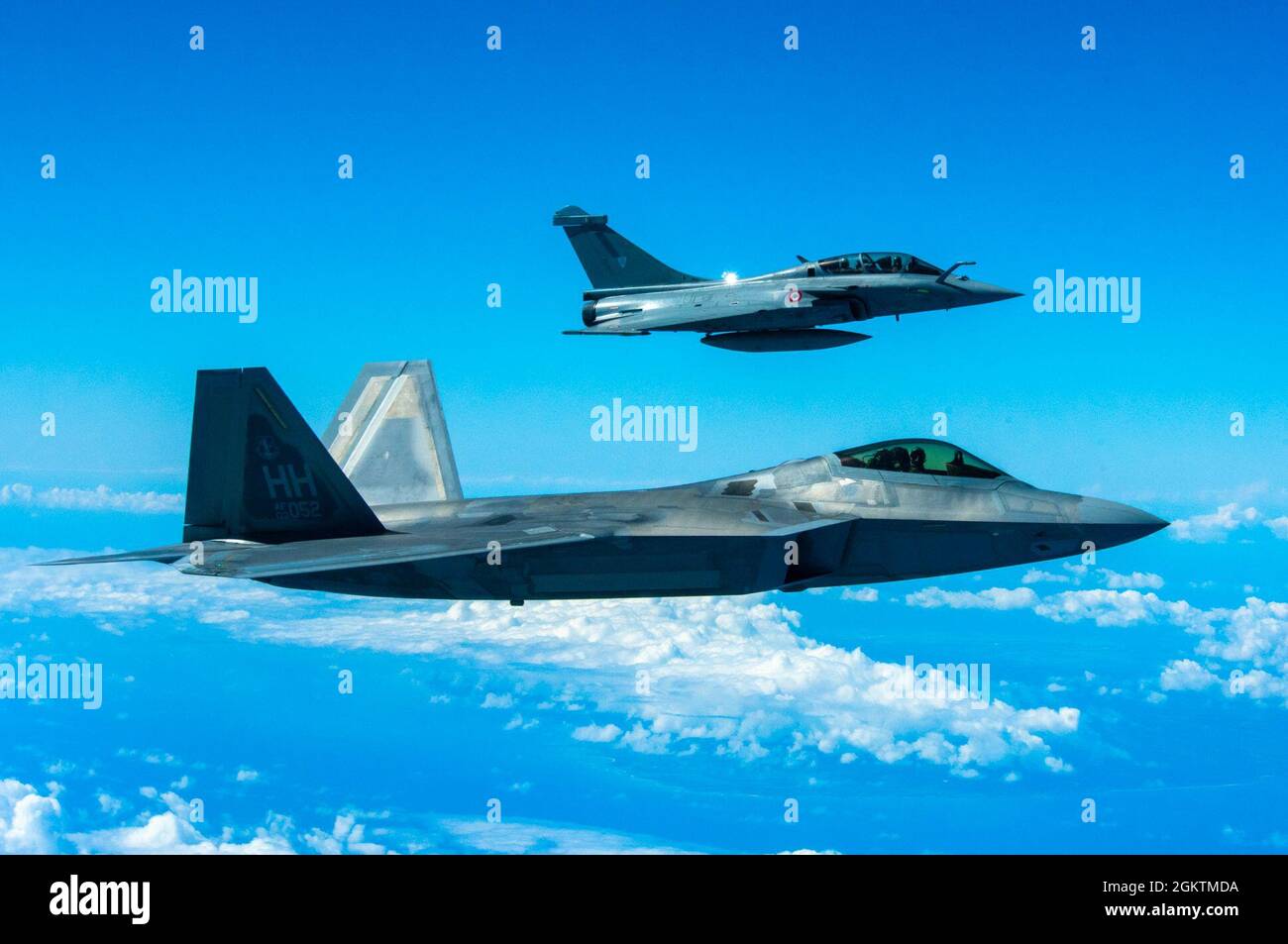 A Hawaii Air National Guard F-22 Raptor flies in formation with a ...