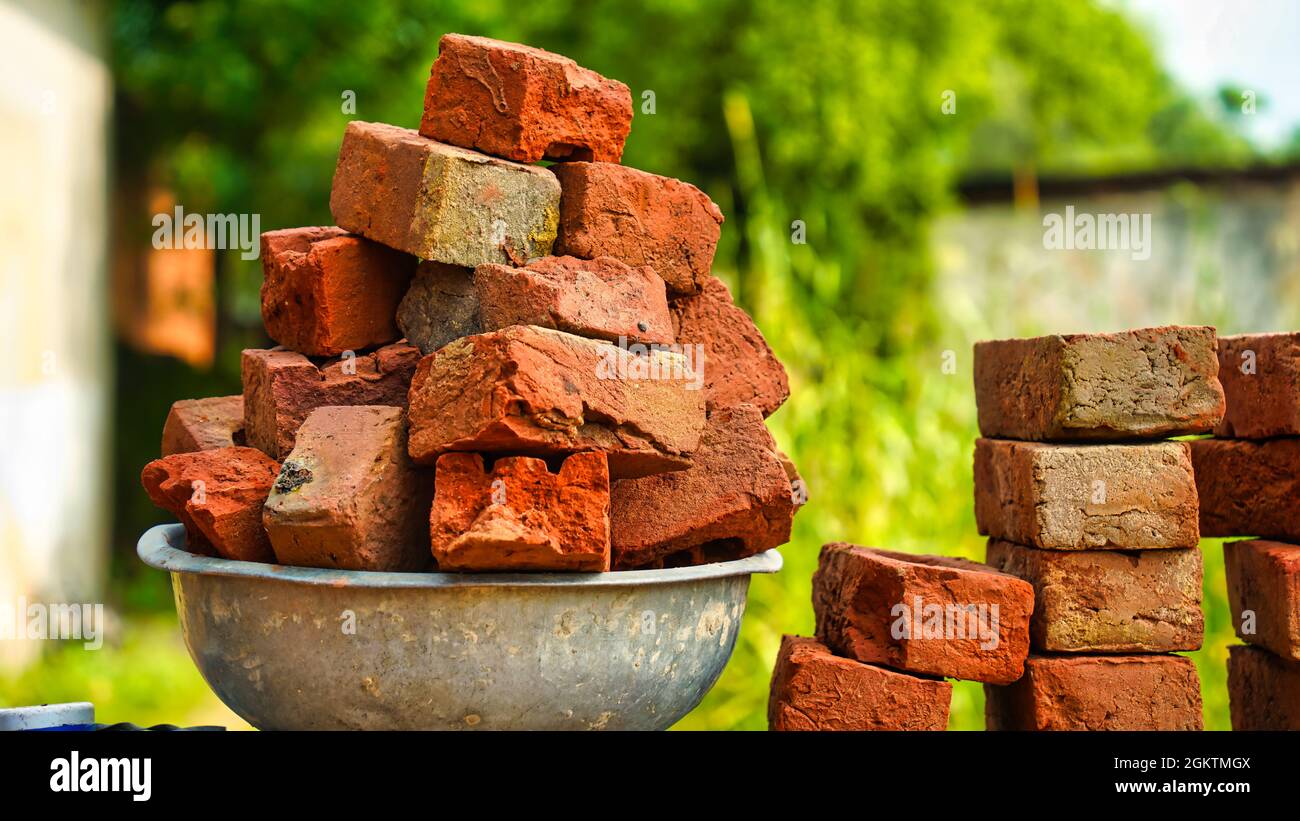 Small pieces of red bricks stored in a iron pot. Construction site ...