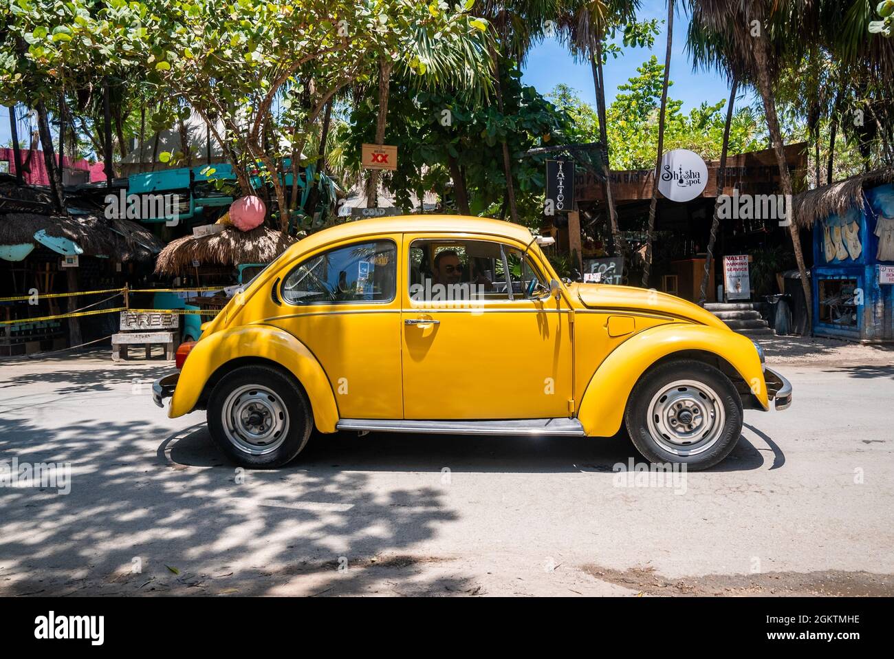Man riding vintage classic car in front of shops and restaurant Stock ...