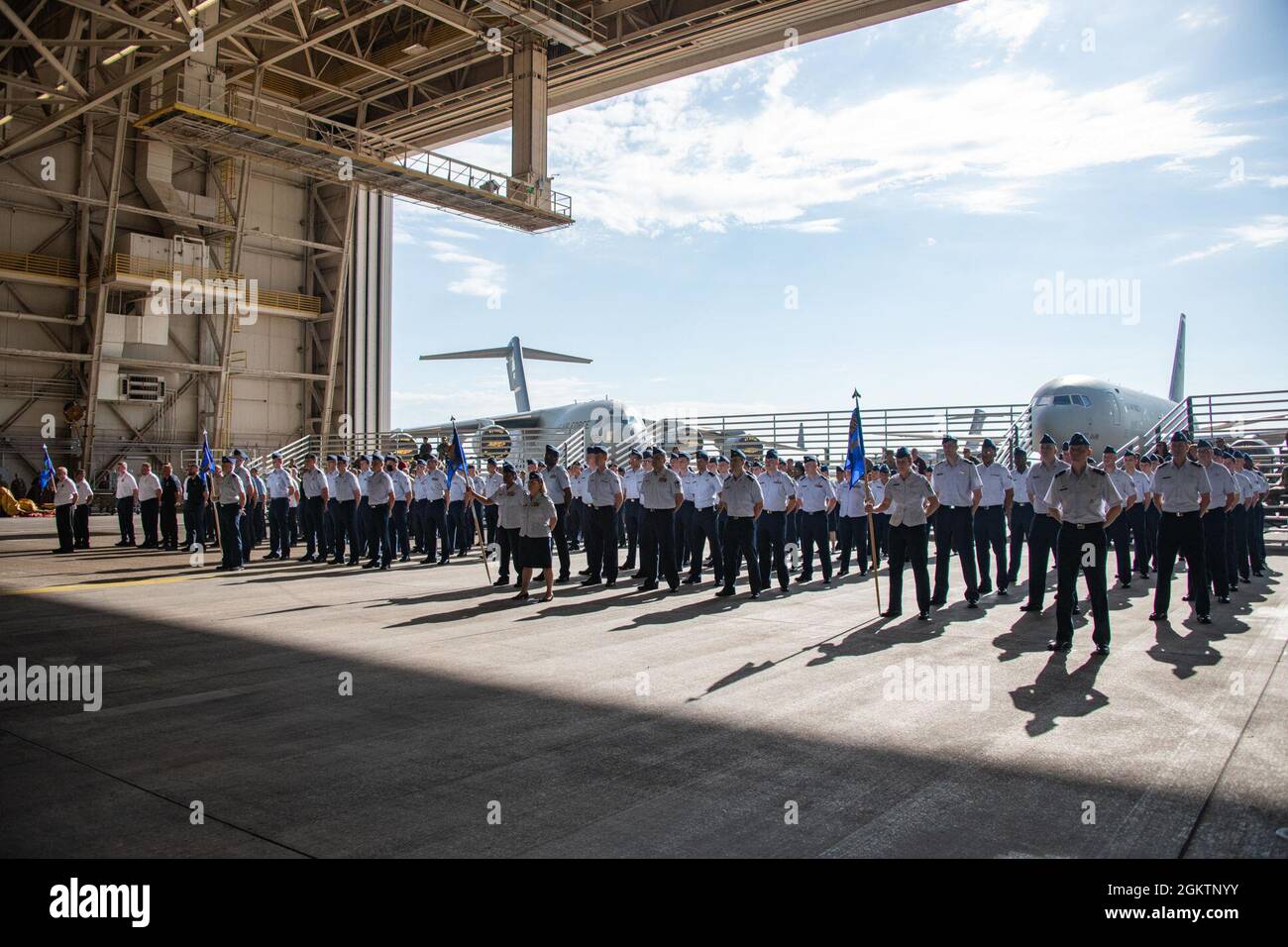 Airmen from the 97th Air Mobility Wing (AMW) stand at parade rest ...