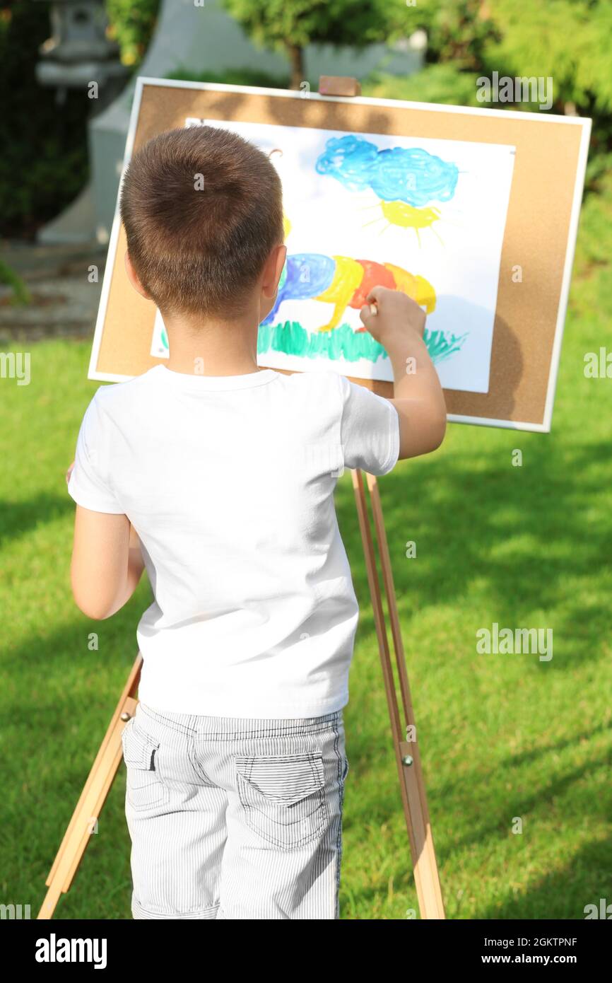 Cute little boy painting picture, outdoors Stock Photo - Alamy