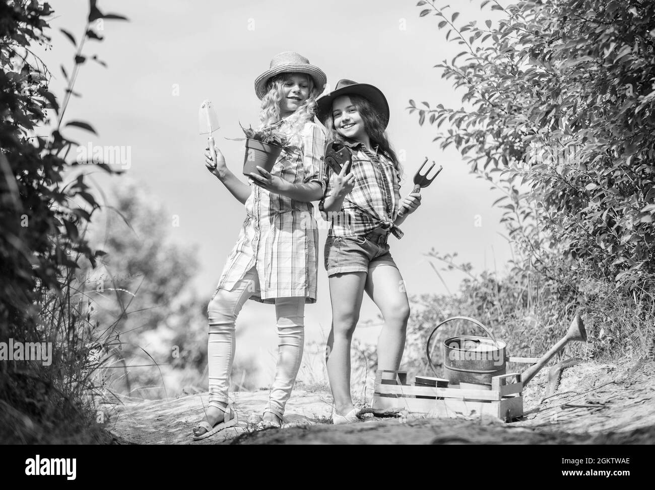 Adorable girls in hats going planting plants. Kids siblings having fun ...