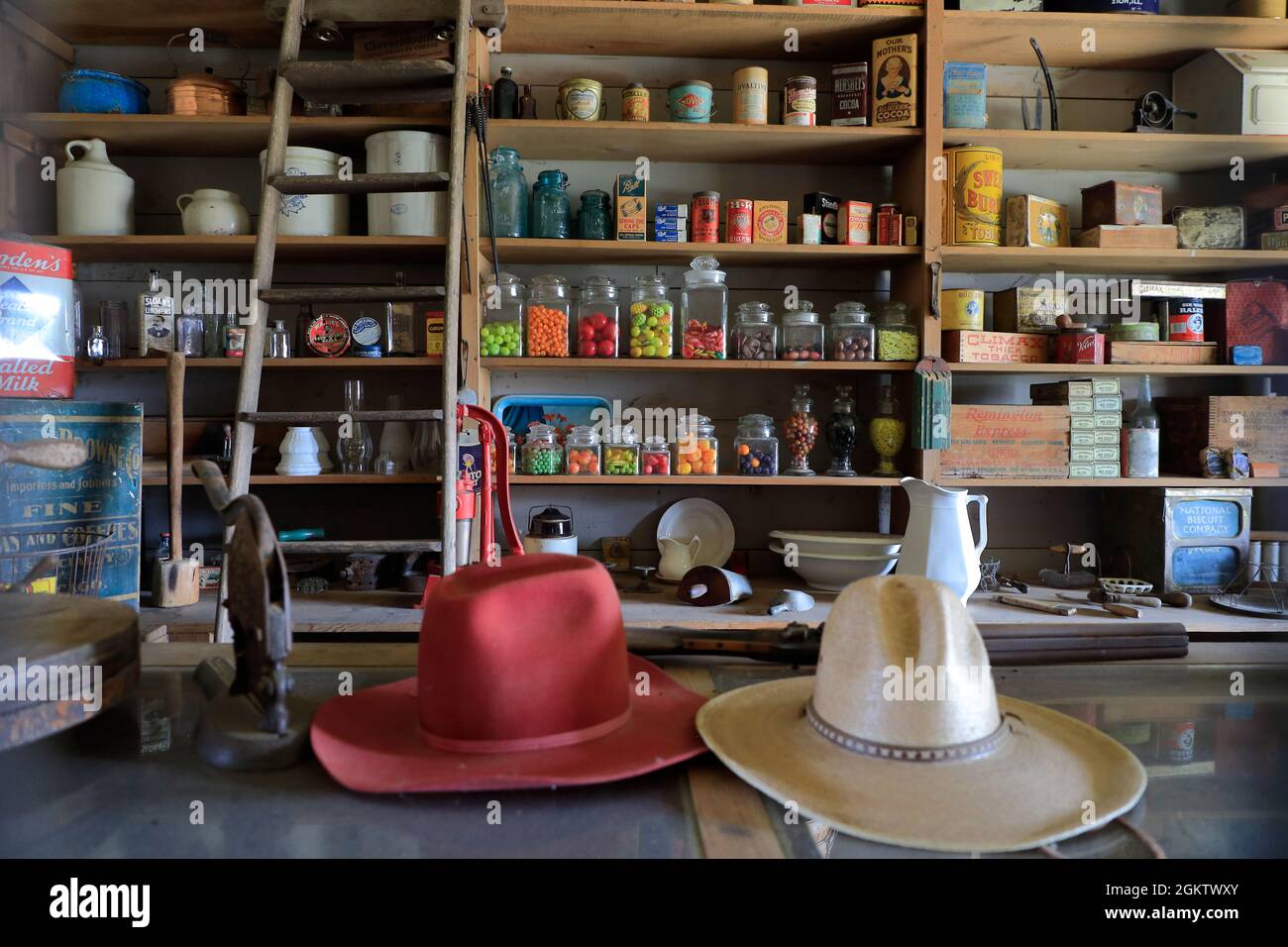 Cowboy hats on the counter with candies containers on the shelf in the ...