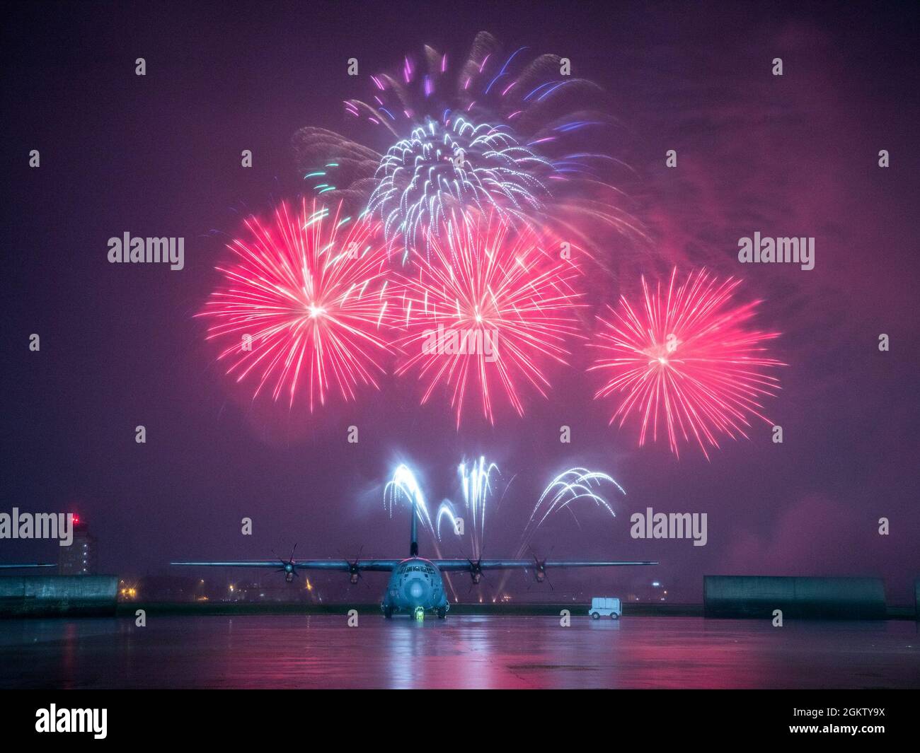 Fireworks explode behind a C-130J Super Hercules at Yokota Air Base ...