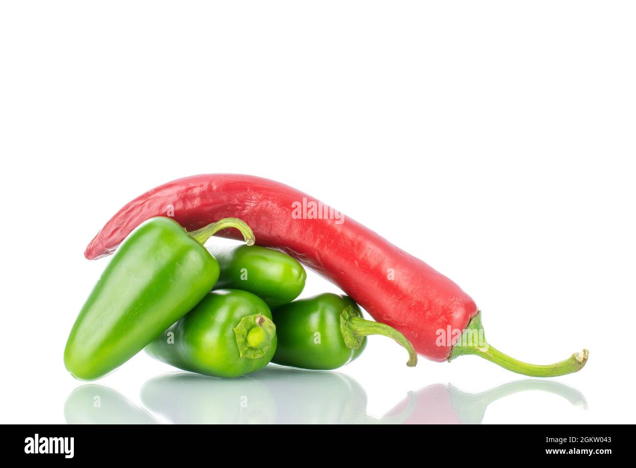One pod of hot red and several pods of green pepper, close-up, isolated ...