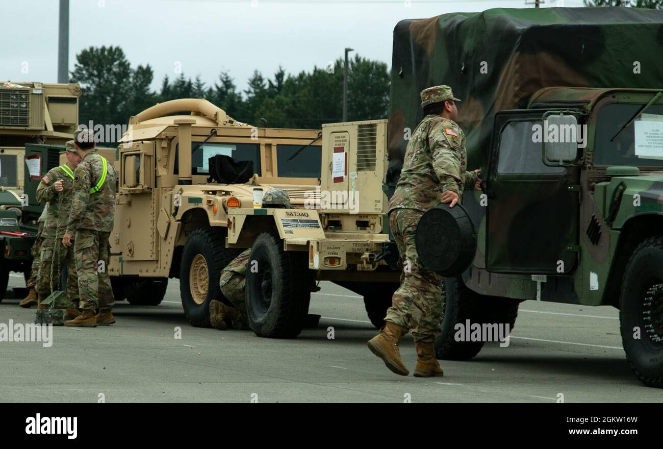 Military vehicles line up to be loaded onto a C-5 Galaxy in preparation ...