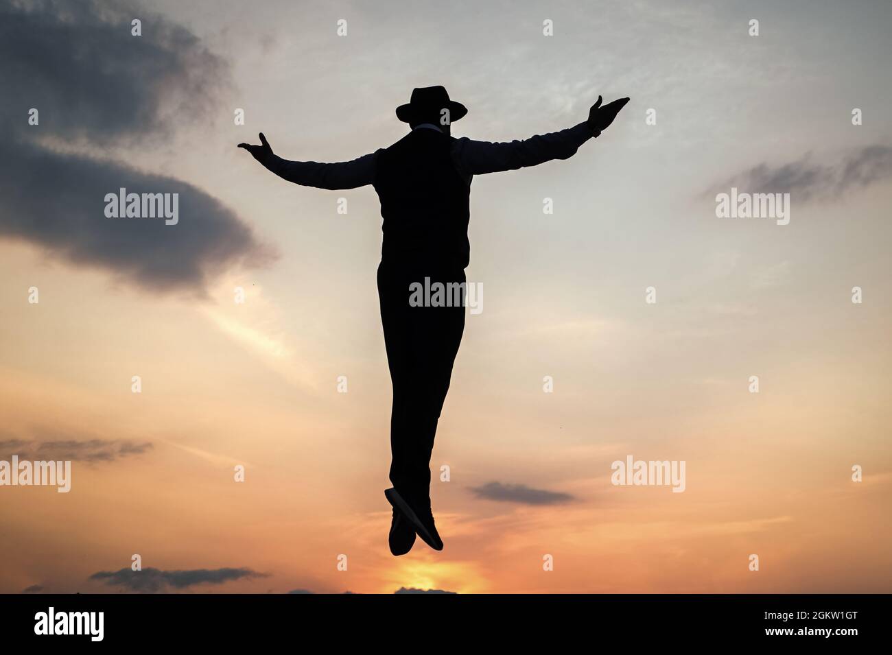 silhouette of man float in sunrise sky with raised hands, freedom Stock ...
