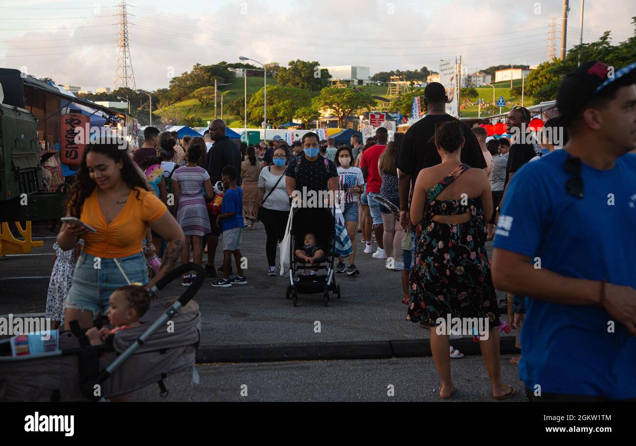 U.S. service members and their families walk through the Camp Foster ...