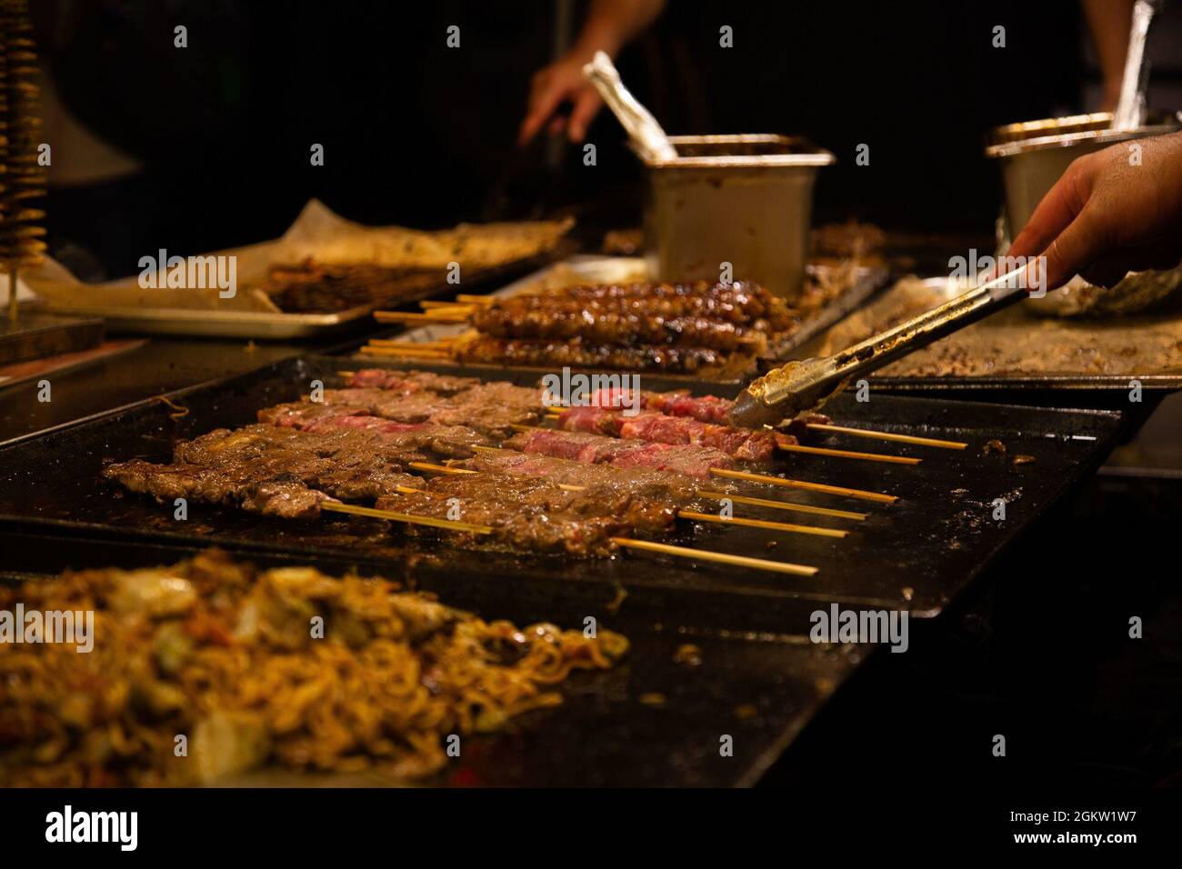 Food is prepared for dozens of customers at a food stand during the ...