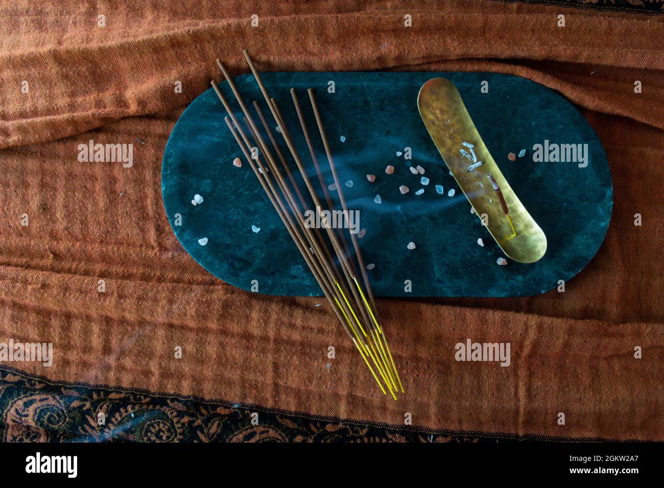 incense laying on a stone tablet and incense burning on the side ...
