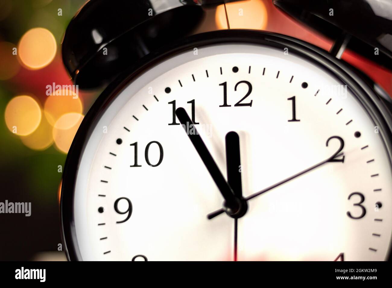 A clock in New Year's decorations is shrouded in spruce branches and ...