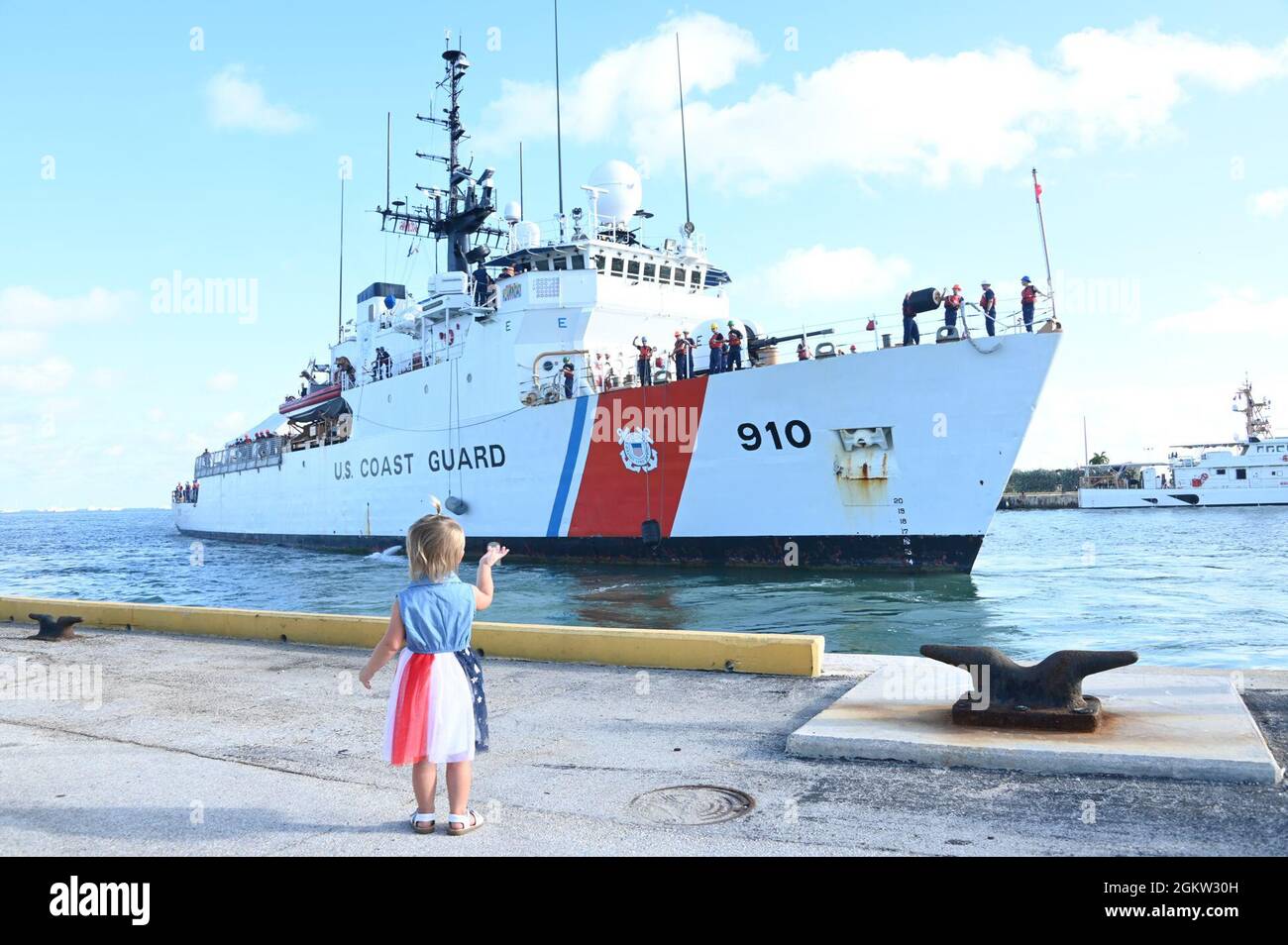 A family member waves goodbye to the crew of the Coast Guard Cutter ...