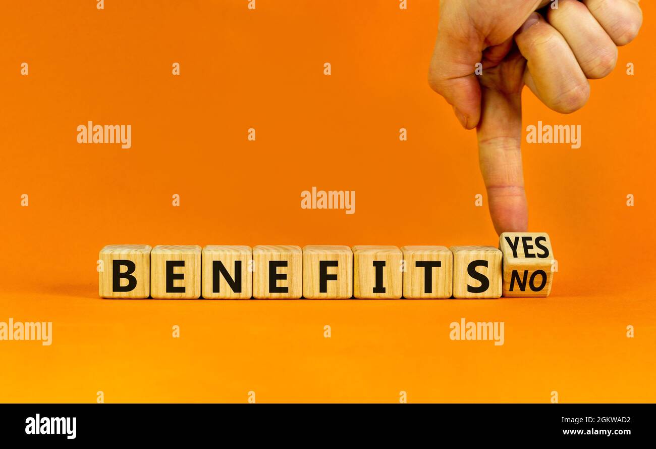Benefits symbol. Businessman turns a wooden cube and change words ...