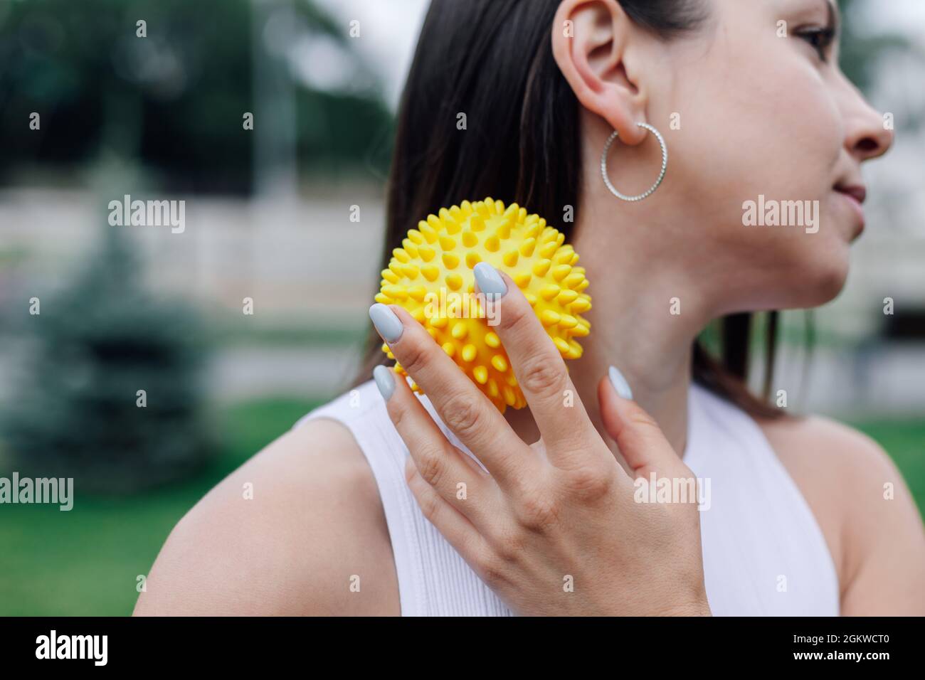 attractive young woman use spiky massage ball to tighten skin and ...