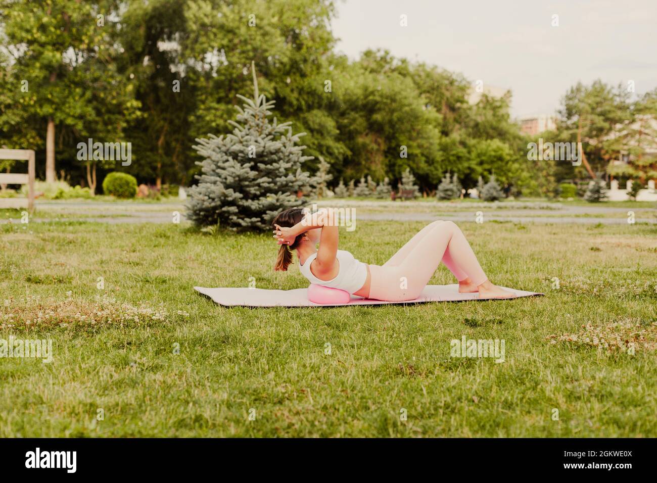 Full Length Slender Woman In Pink Top Lies With Back On Pink Small