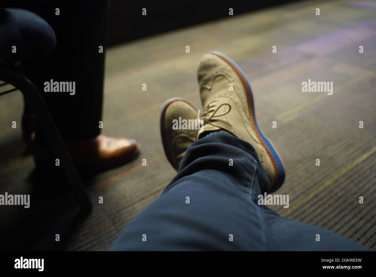 Man legs crossed wearing green shoes Stock Photo - Alamy