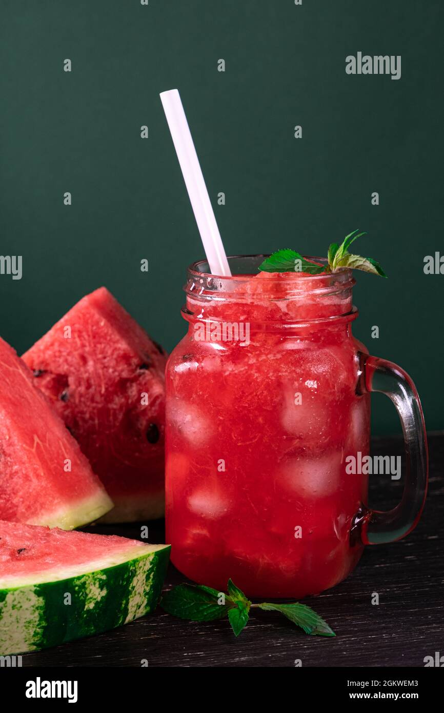 Cold watermelon smoothie and pieces of refreshment watermelon on dark ...