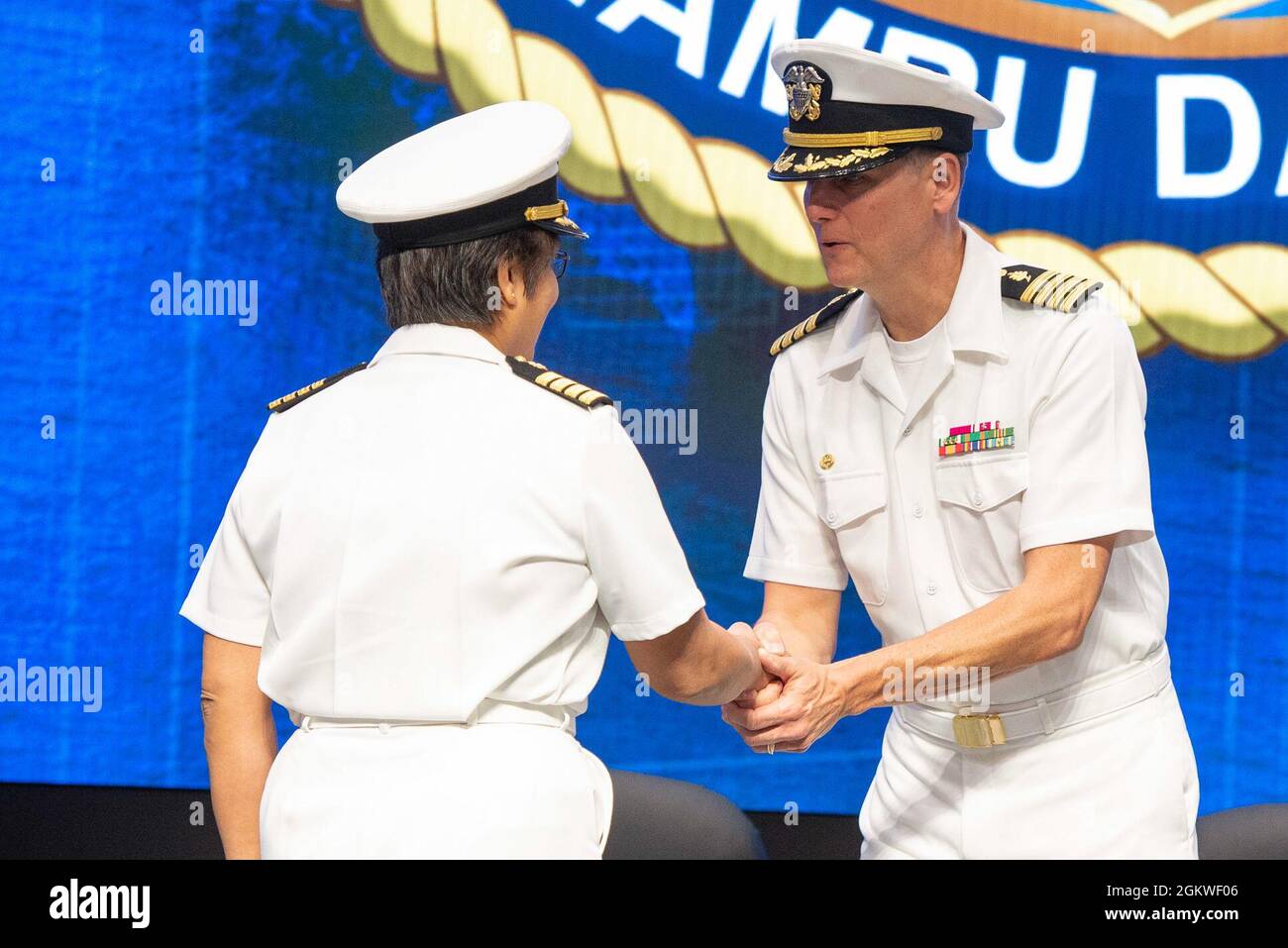 U.S. Navy Capt. Nimfa Teneza-Mora, outgoing commander of Navy Medical Research Unit Dayton, left ...