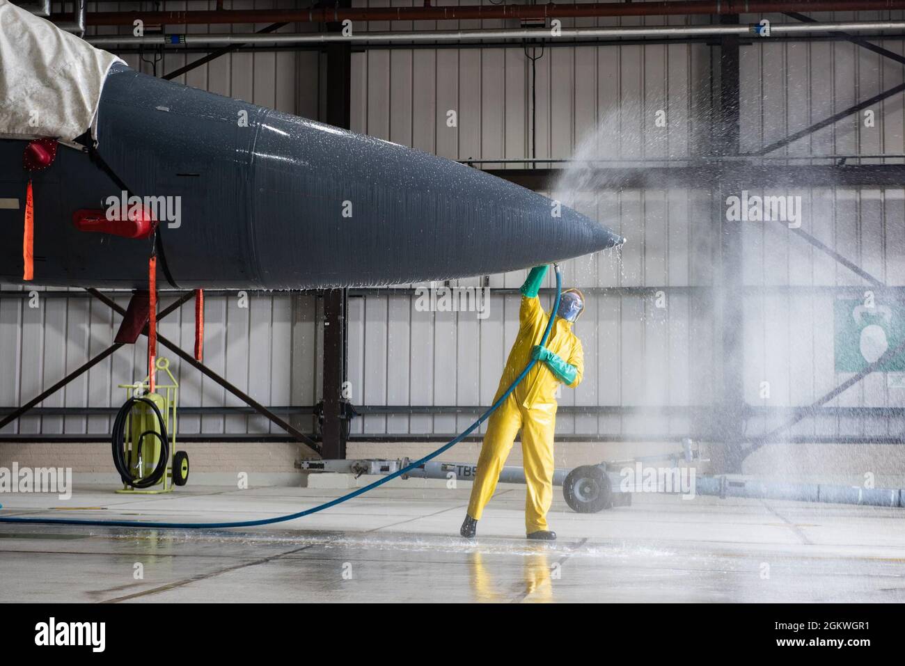 Anthony Grant, an aircraft wash facility team member, rinses the nose ...