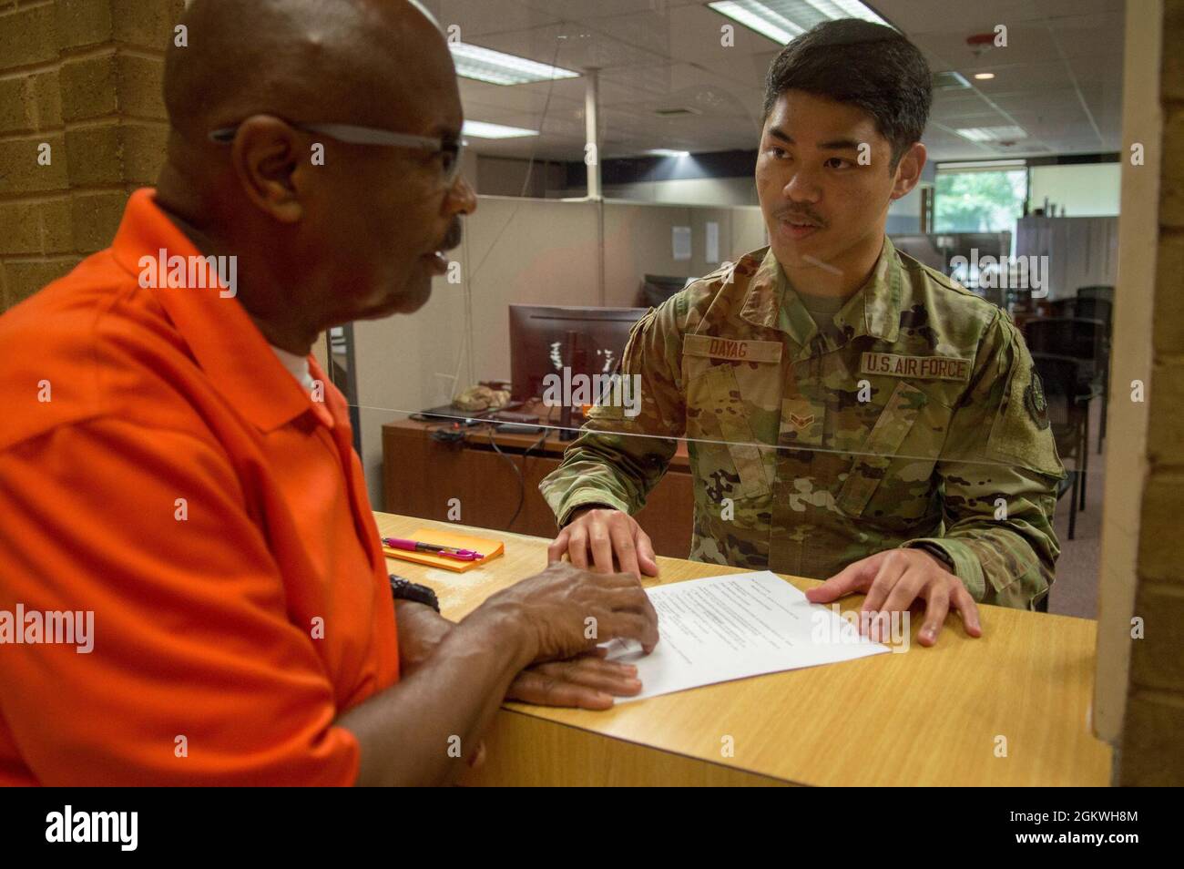 U.S. Air Force Airman 1st Class Isaac Dayag assists personnel in the ...