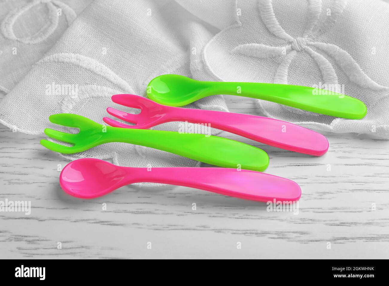 Colorful plastic eating utensils for baby on table Stock Photo - Alamy