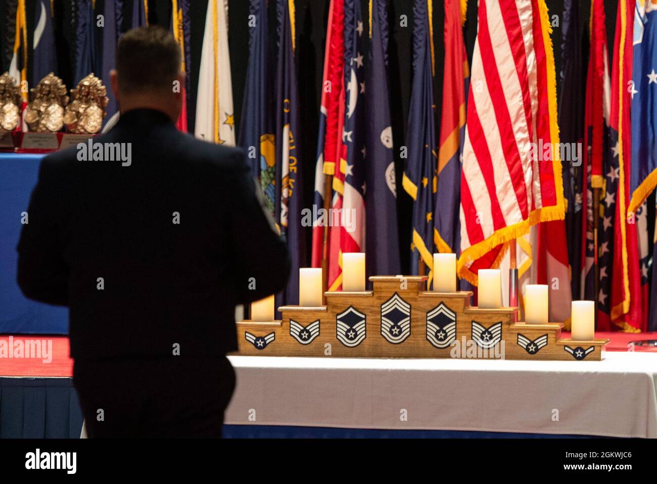 A chief master sergeant prepares to place the final candle on the ...