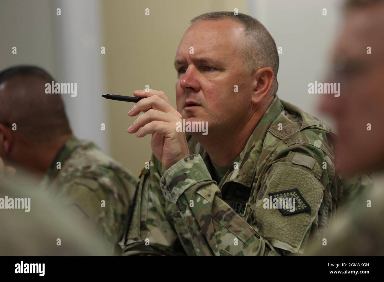 Brig. General Brad Cox receives updates from his staff members at a ...
